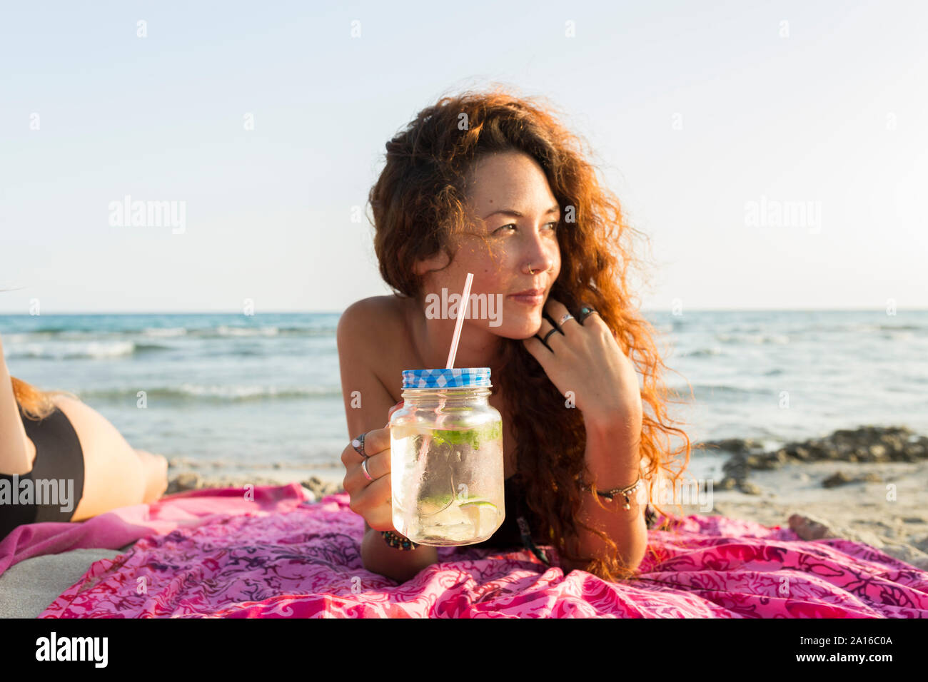 Young woman lying at the beach Stock Photo - Alamy