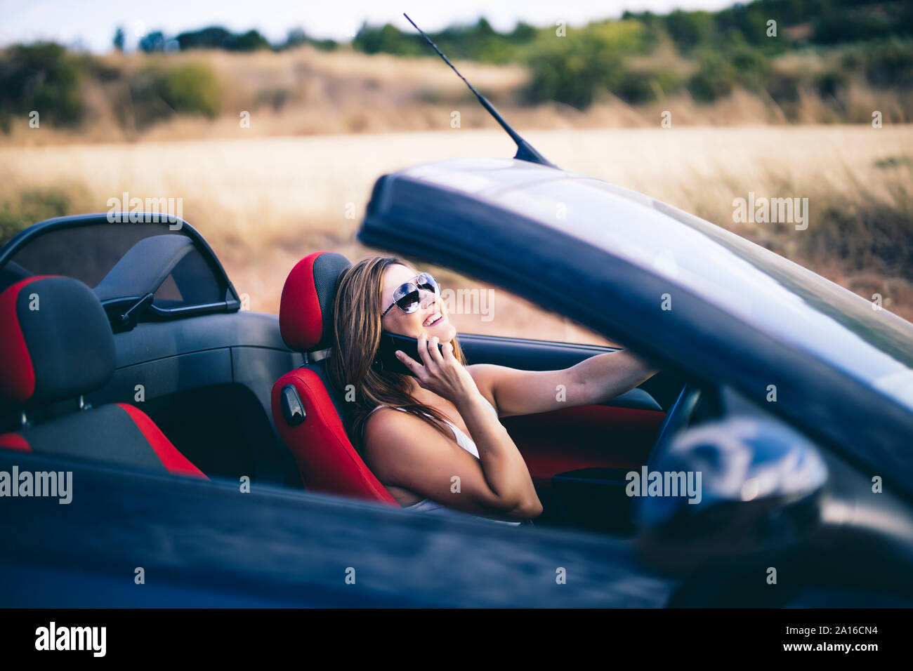 Using smartphone in her convertible hi-res stock photography and images ...