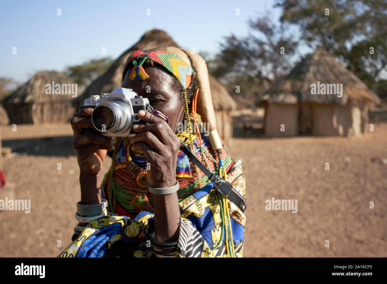 Muhila traditional woman taking pictures with a camera, Kehamba, Chibia ...
