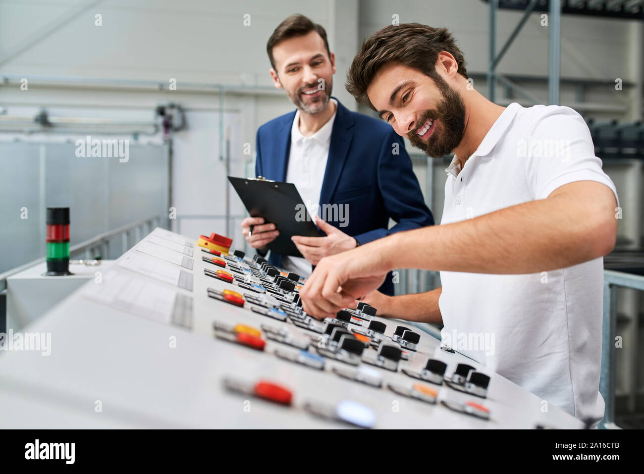 Businessman and employee talking at control panel in a factory Stock ...