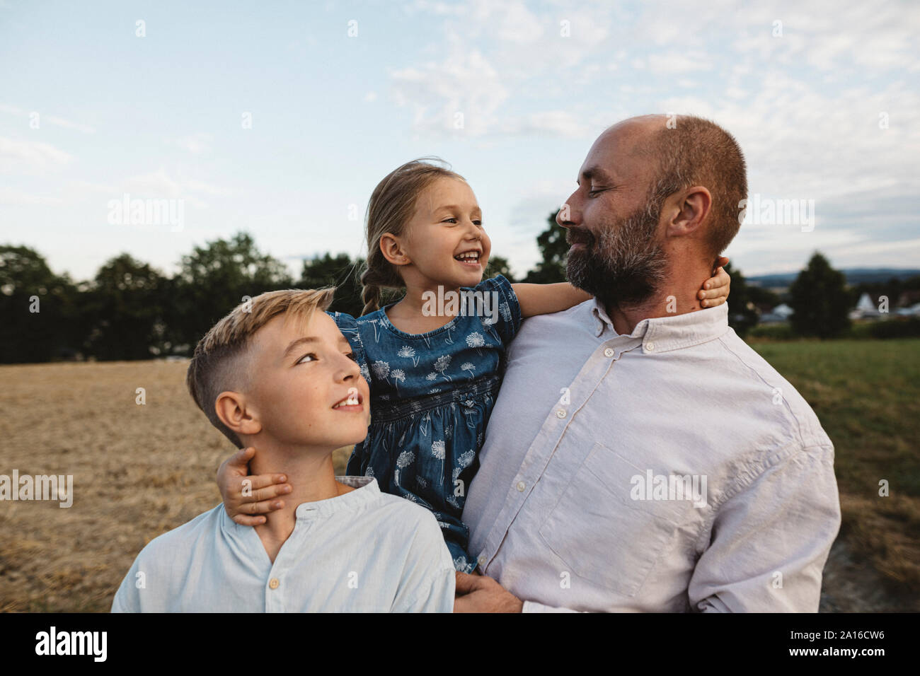 Affectionate father with two children outdoors Stock Photo - Alamy