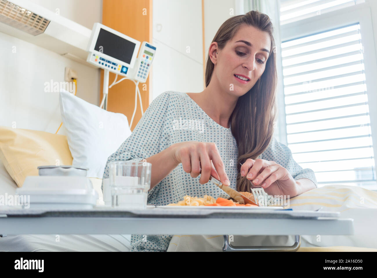 Patient in hospital lying in bed eating meal enjoying the food Stock ...