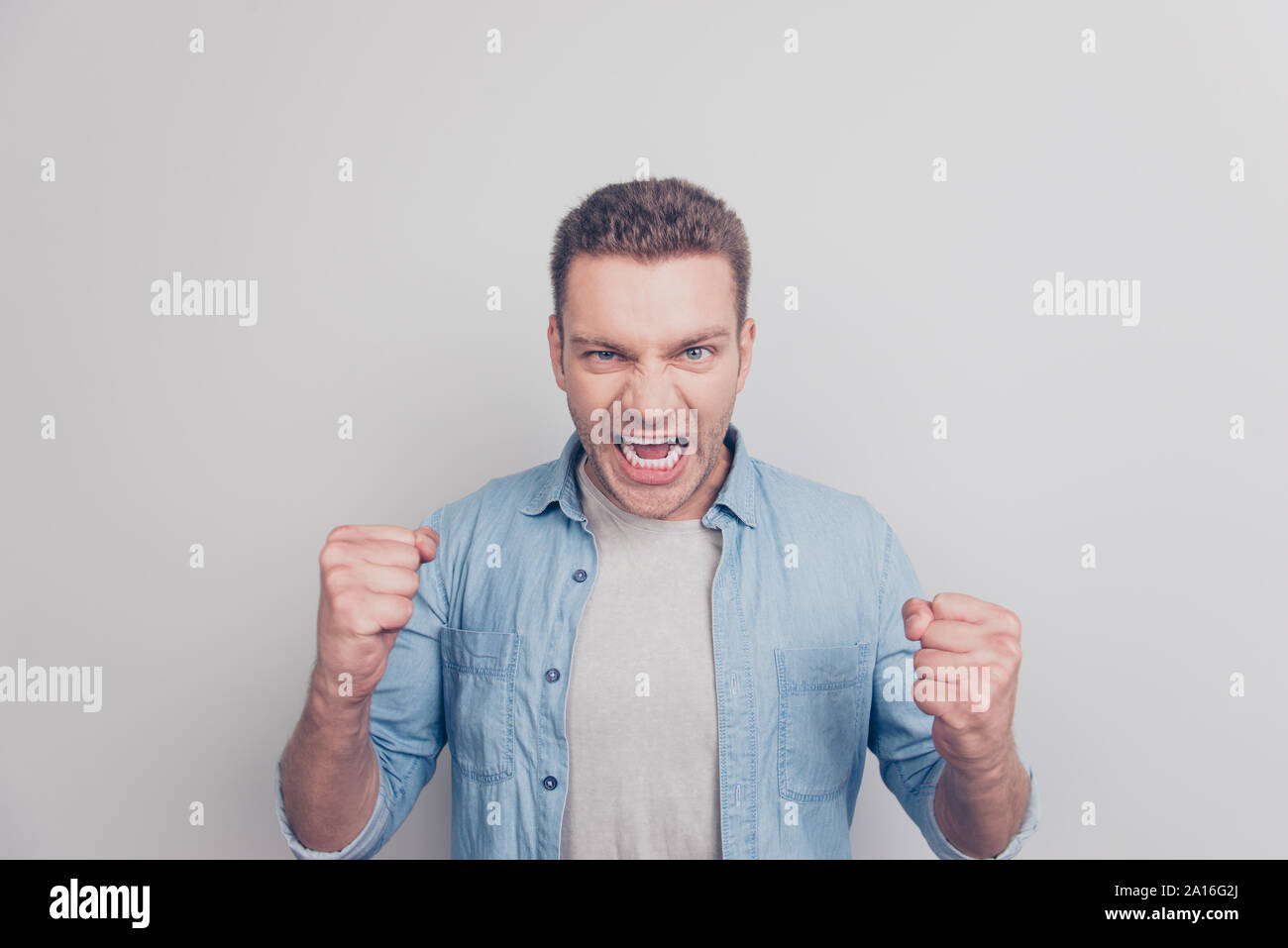 Photo of evil sad insane man look at camera hold fist on two han Stock ...