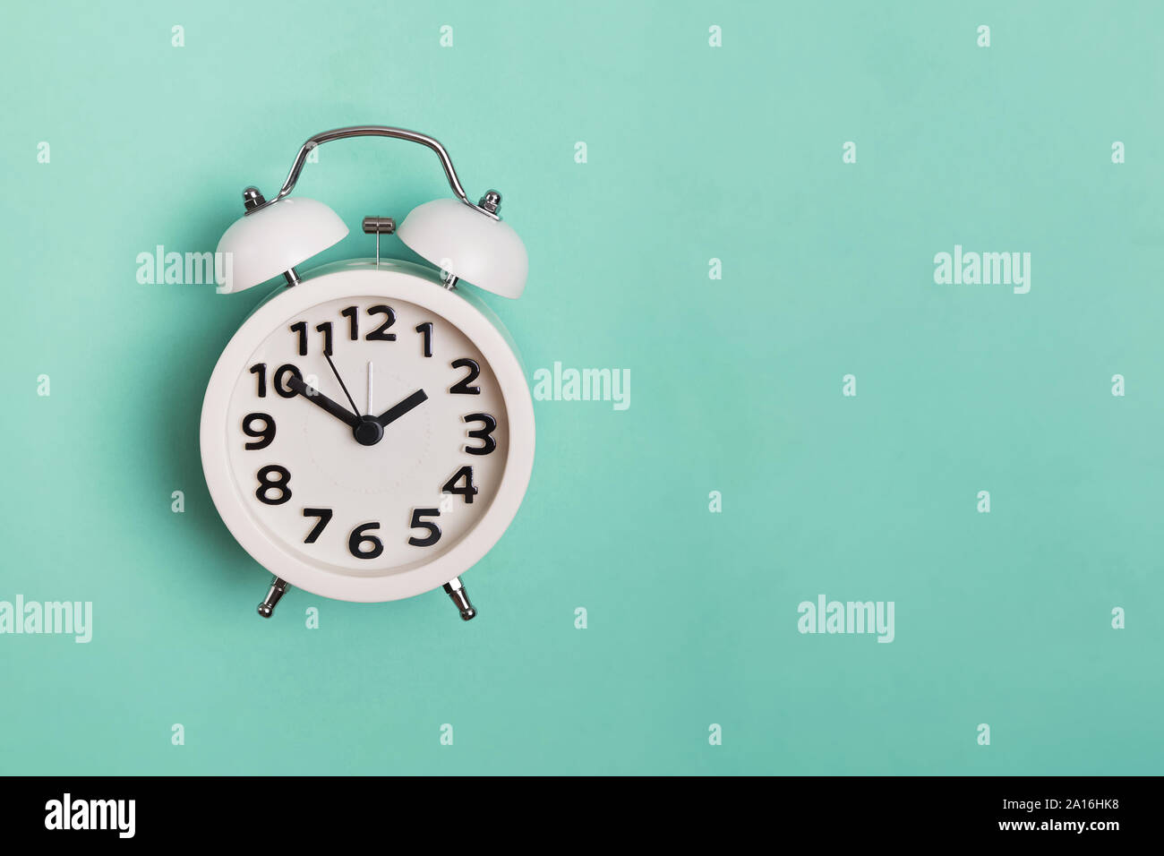Vintage alarm clock isolated on pastel mint background Stock Photo - Alamy