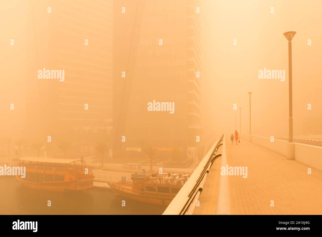 DUBAI - A woman and a child on a bridge in Dubai Marina seen through ...