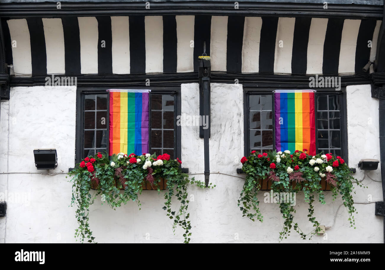 A wooden beamed building in Chester with rainbow coloured flags on the ...