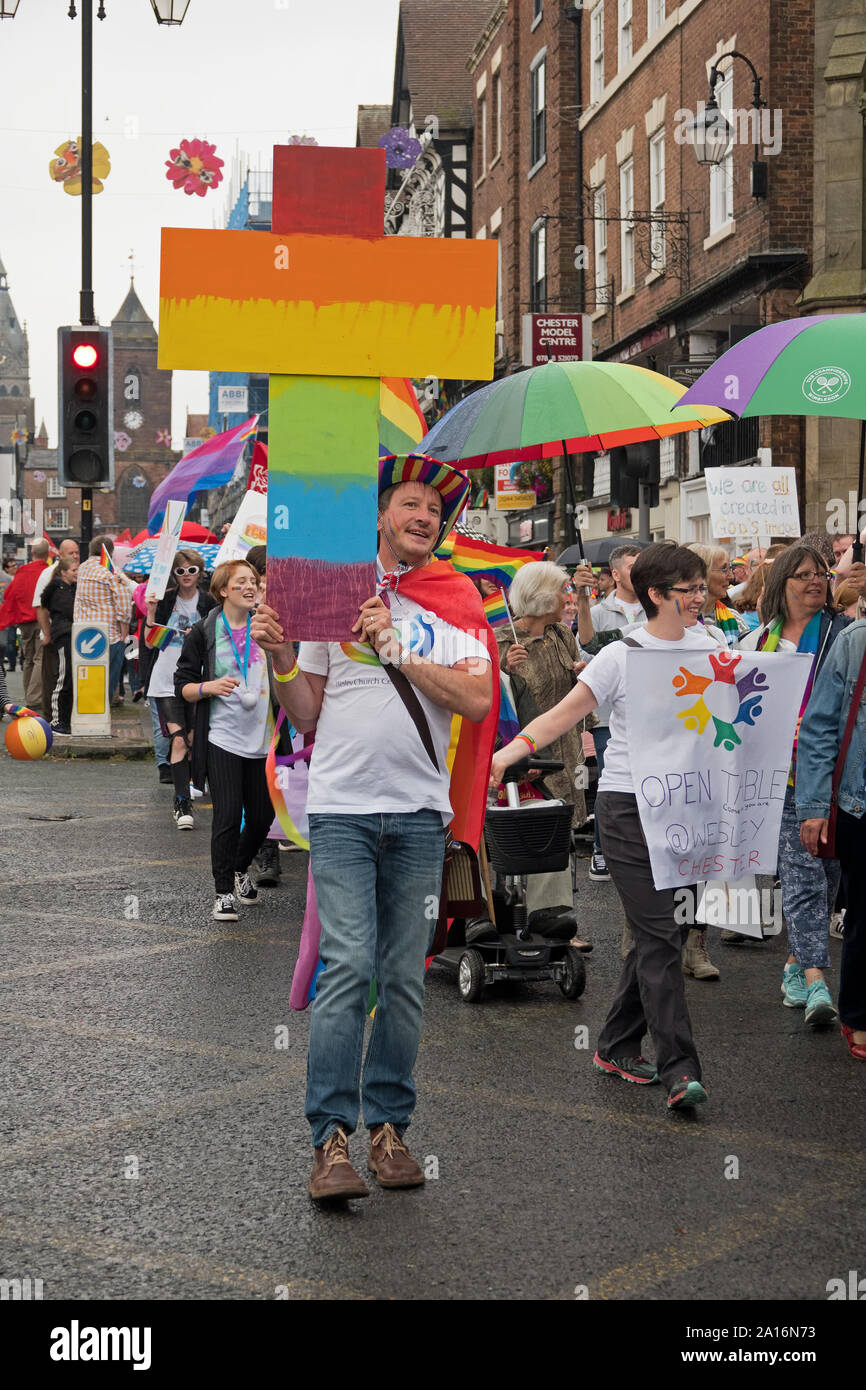 A man carrying a rainbow coloured cross at the 2019 Chester Pride ...