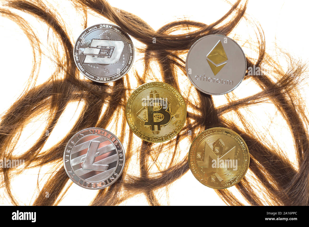 Lined up crypto currency coins displayed on a heap of cut out woman ...