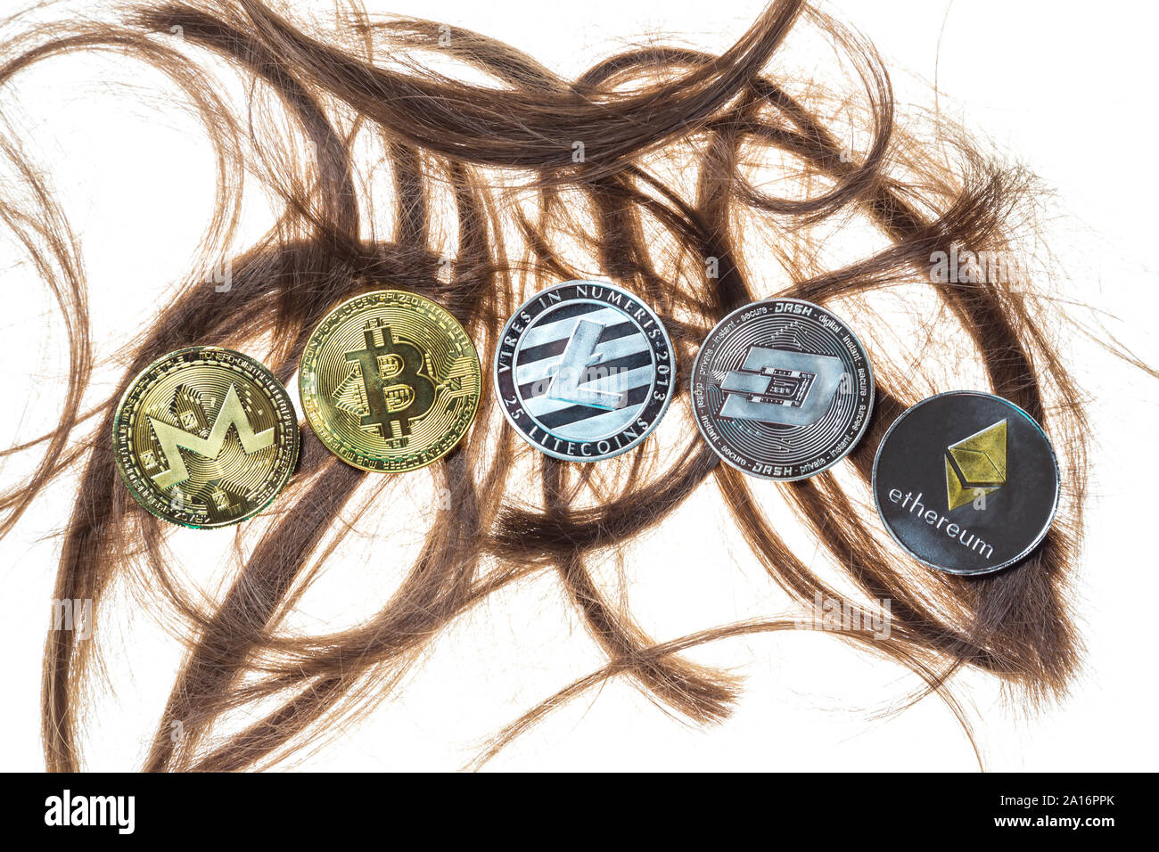 Lined up crypto currency coins displayed on a heap of cut out woman ...