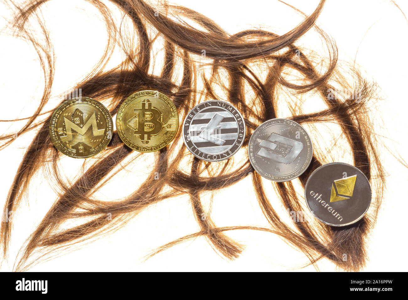 Lined up crypto currency coins displayed on a heap of cut out woman ...