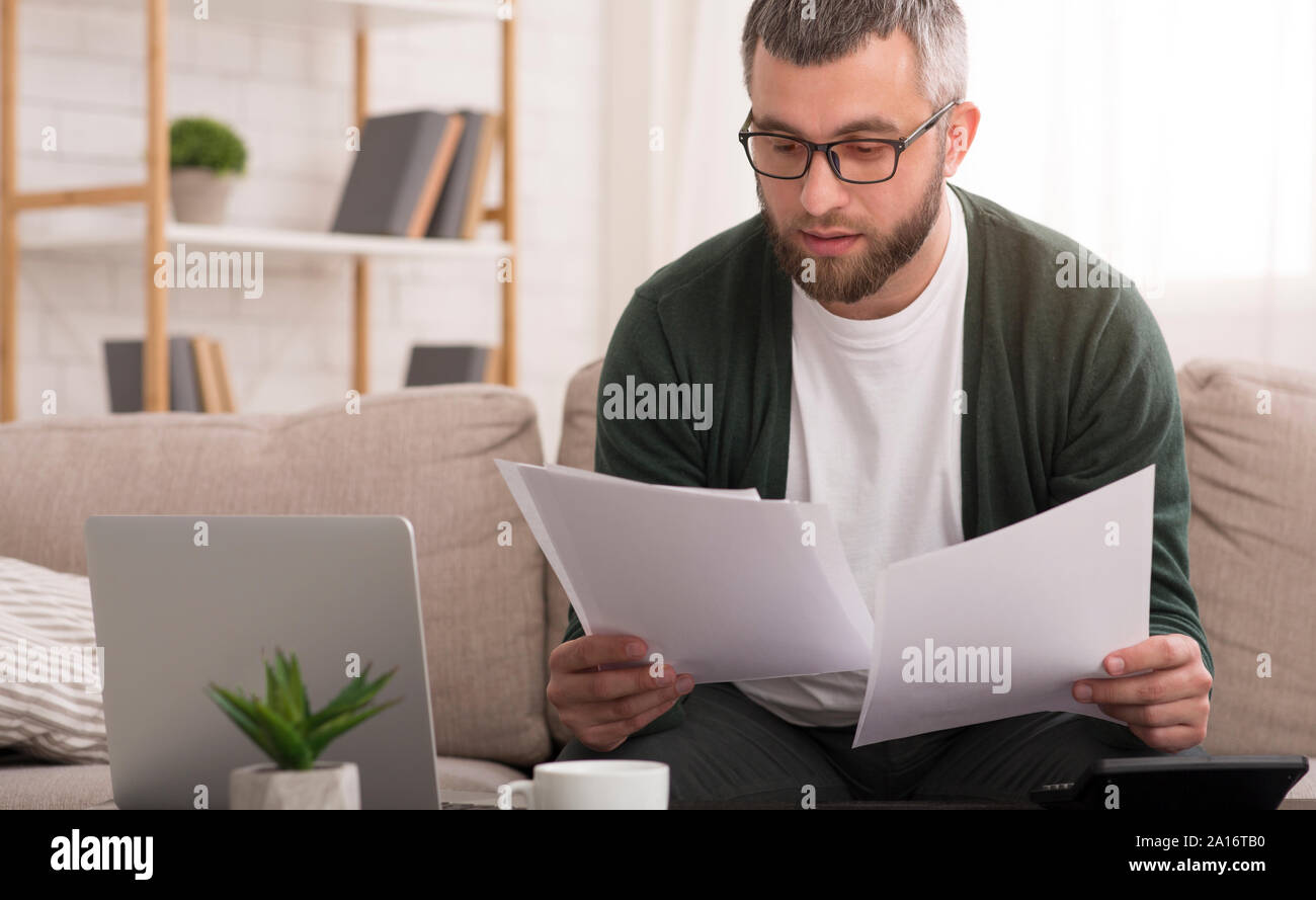 Man holding documents with both hands, reading it Stock Photo - Alamy