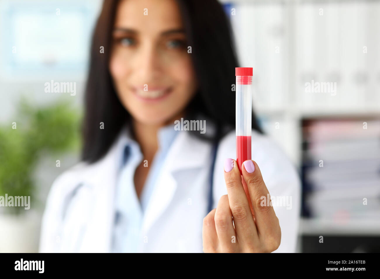 Female doctor hand holding plastic testing tube containing red liquid ...