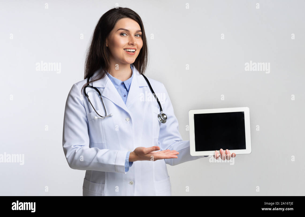 Positive Doctor Using Tablet Giving A Presentation On White Background ...