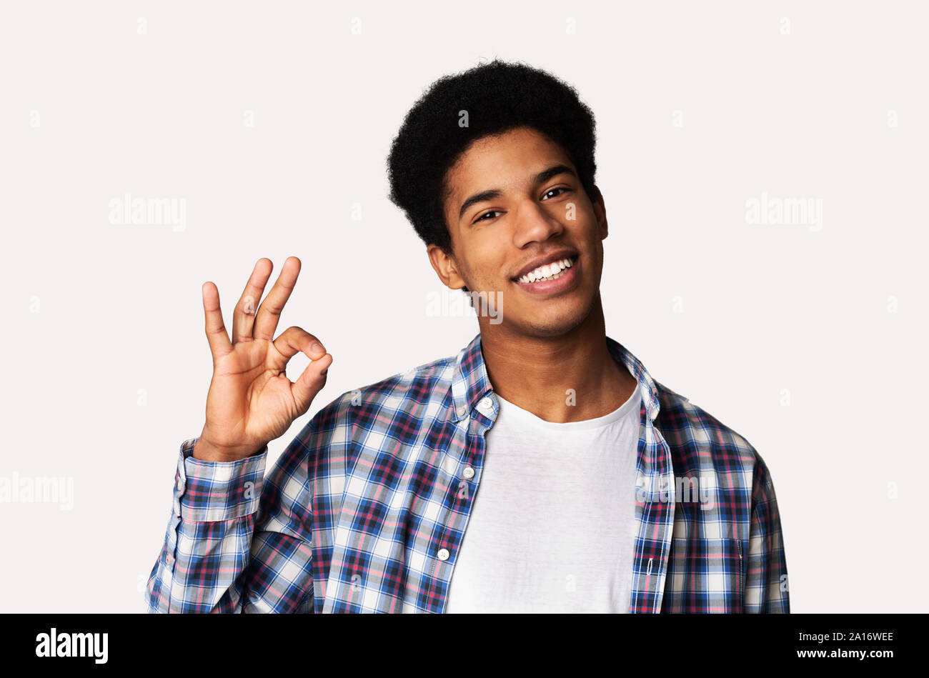 Happy african guy gesturing OK sign and smiling Stock Photo - Alamy