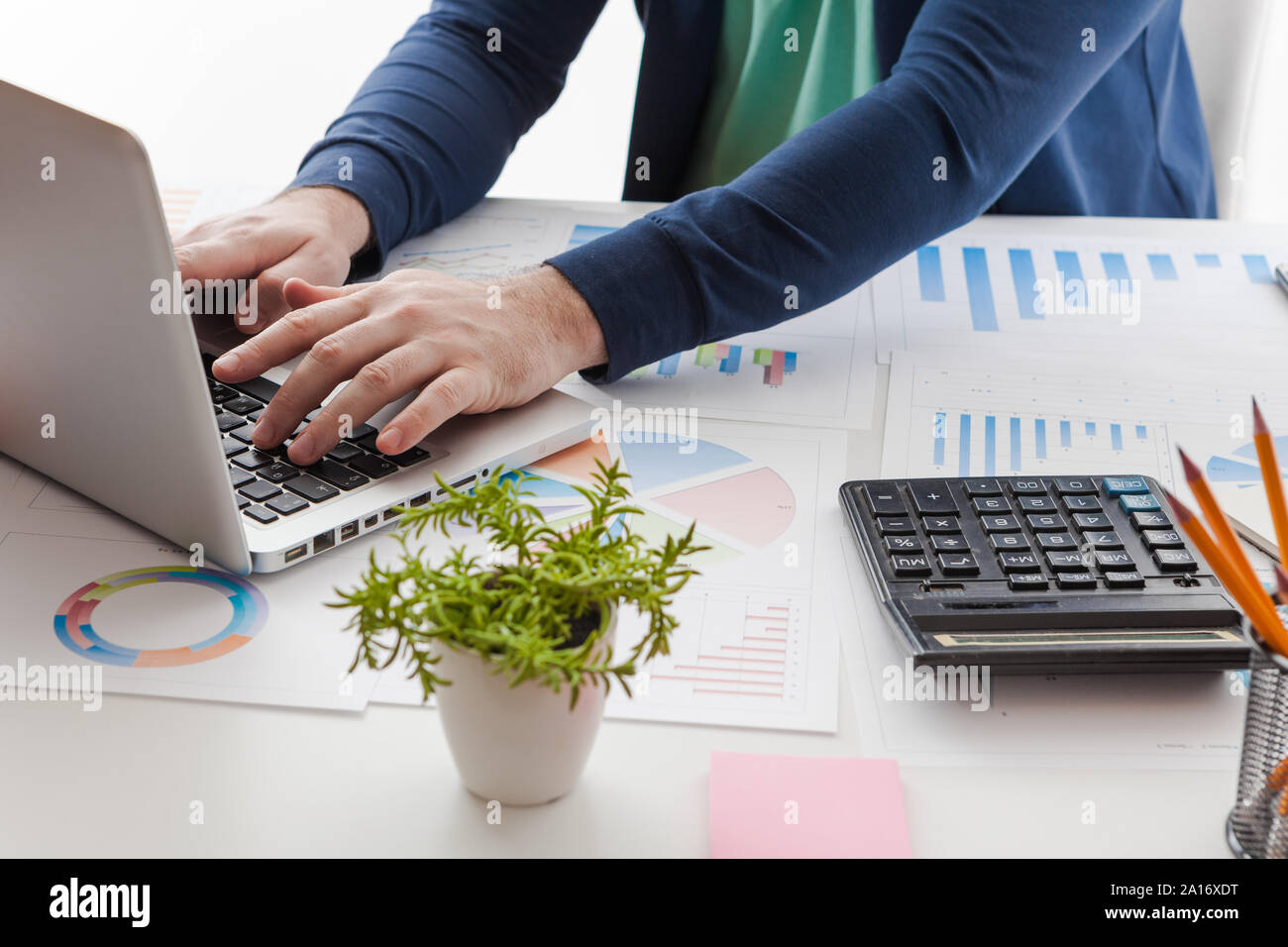 Businessman holding a pen is working with graph documents and sunset ...