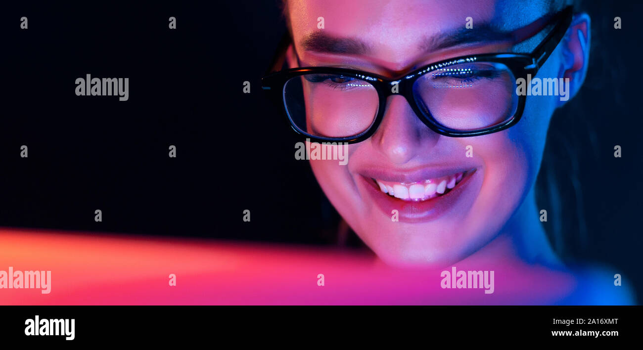Happy girl looking at laptop screen at night Stock Photo - Alamy
