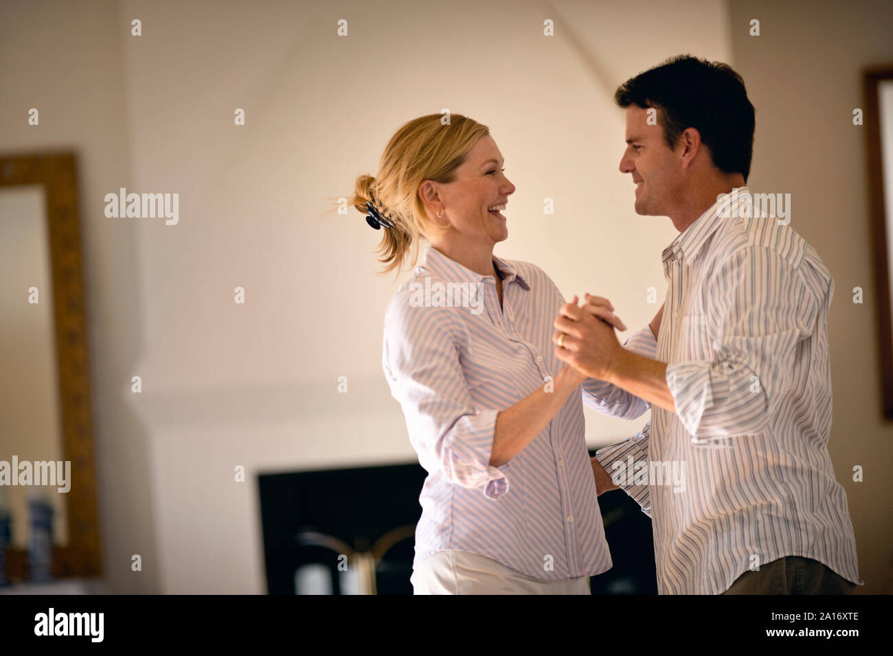 Couple dancing playfully in their living room together Stock Photo - Alamy