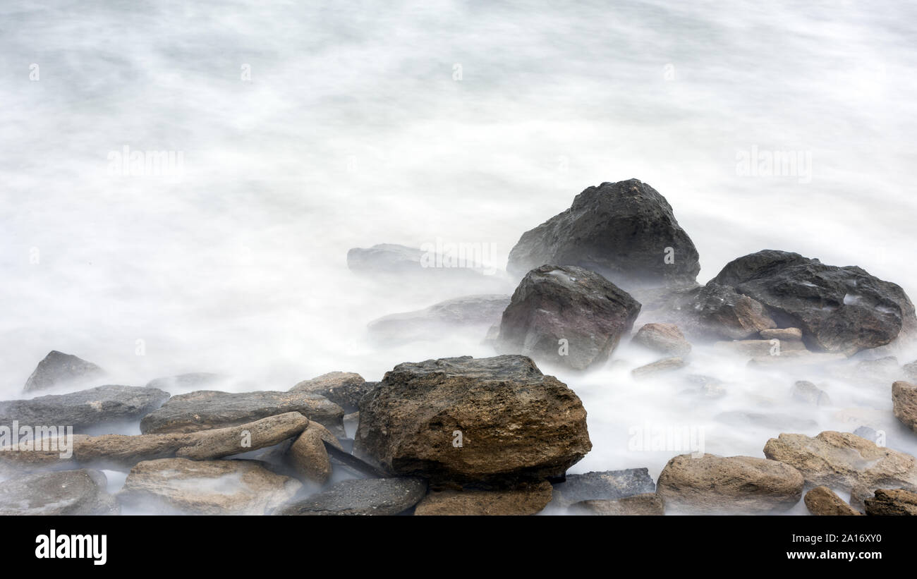 Storm in the sea, big foamy waves crash on rocks Stock Photo - Alamy