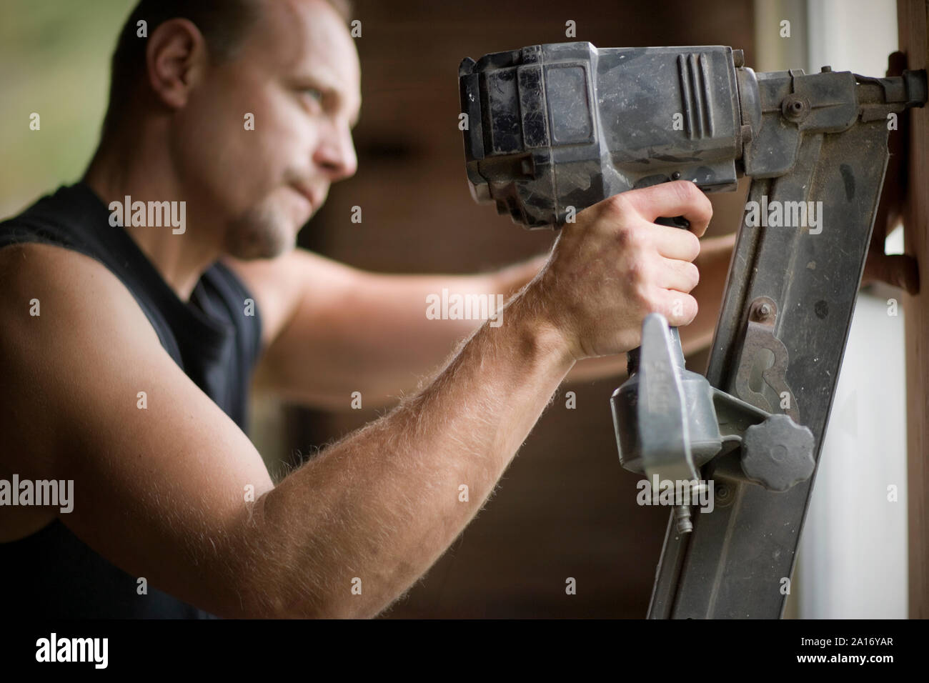 Male builder using a construction tool Stock Photo - Alamy