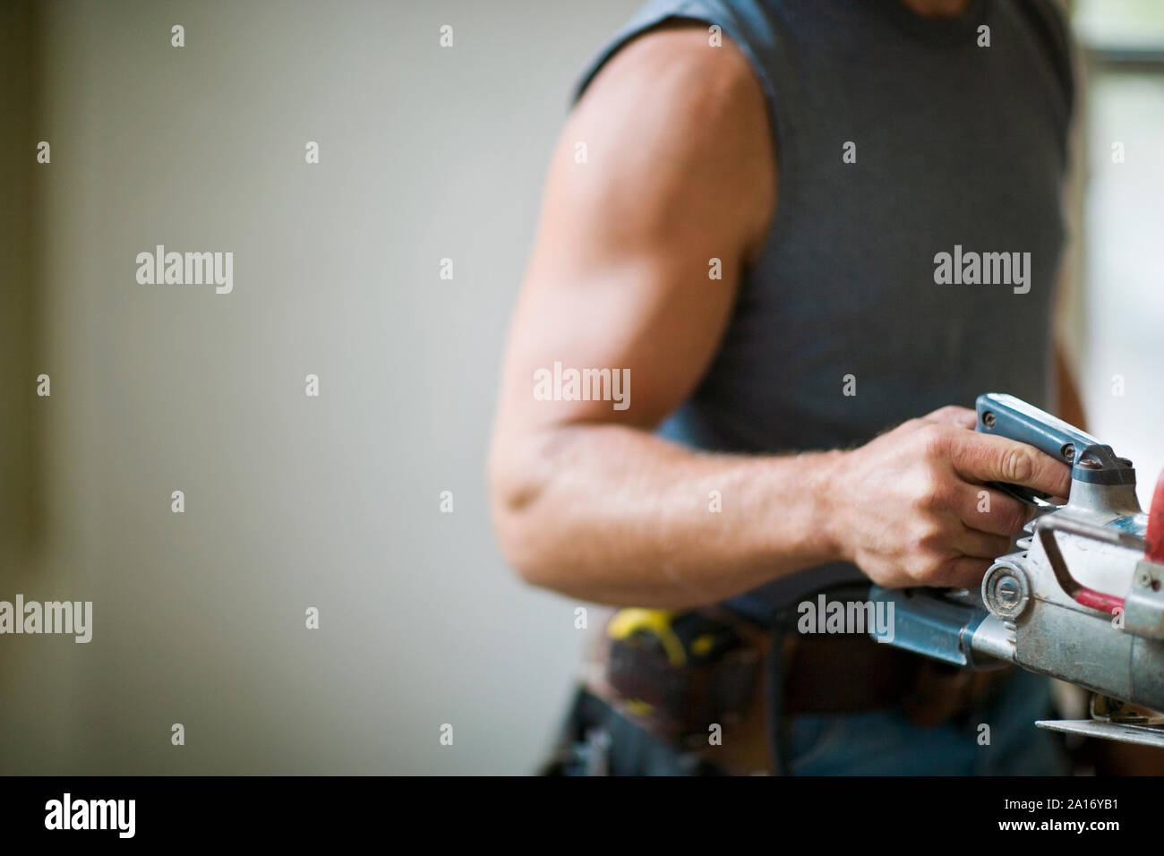 Male builder carrying a construction tool Stock Photo - Alamy