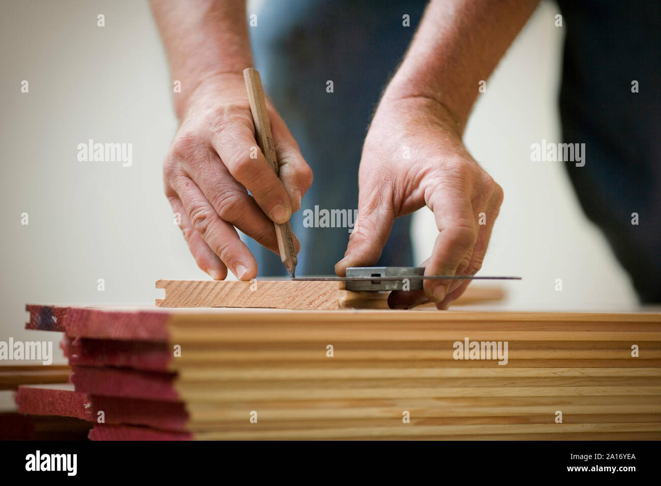 Hands of a male builder measuring a door and marking it with a pencil ...