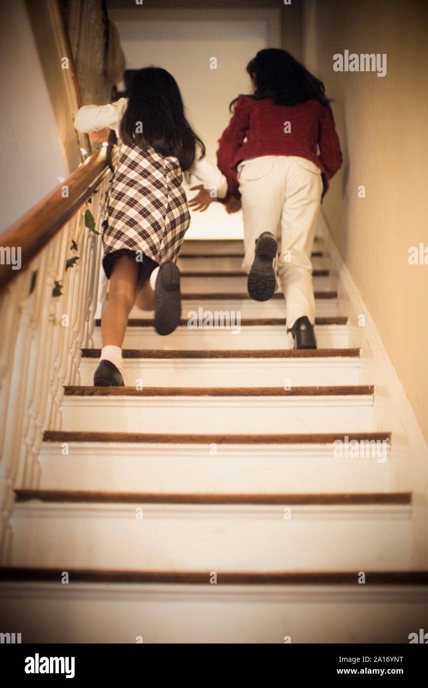 Two girls are climbing a staircase Stock Photo - Alamy