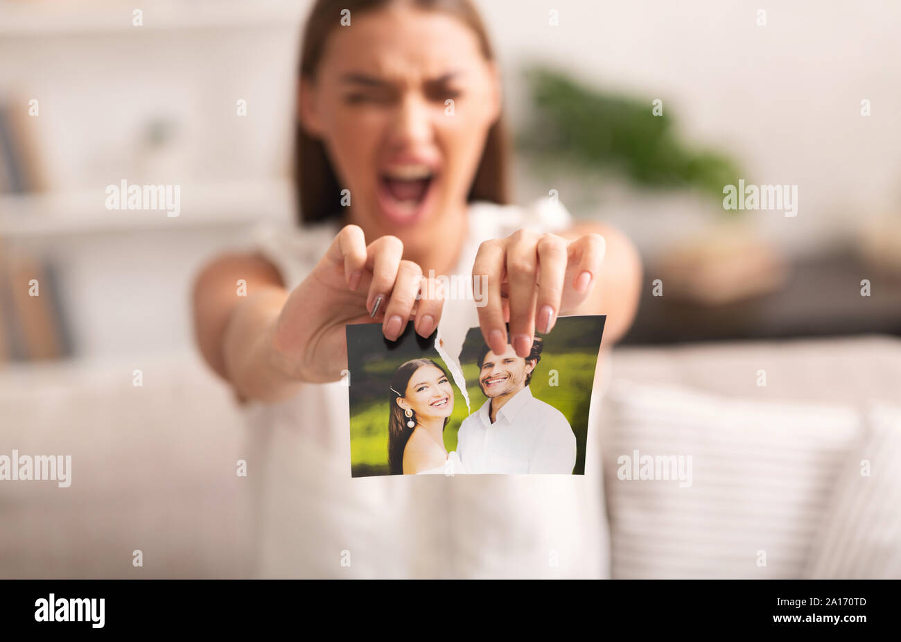 Angry Woman Ripping Photo With Ex-Husband Indoor Stock Photo - Alamy