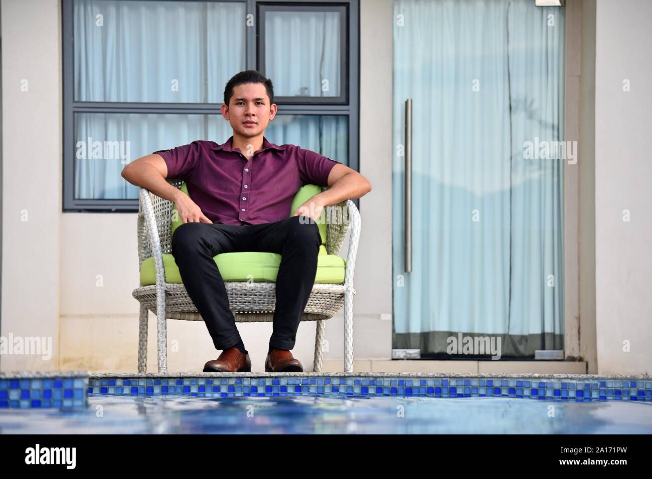 Man sitting by swimming pool hi-res stock photography and images - Alamy