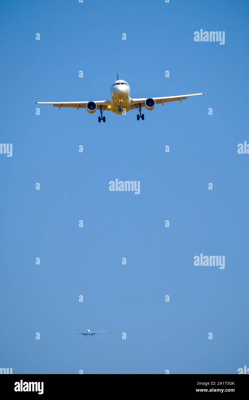 Passenger airplane flying in blue sky, front view Stock Photo - Alamy