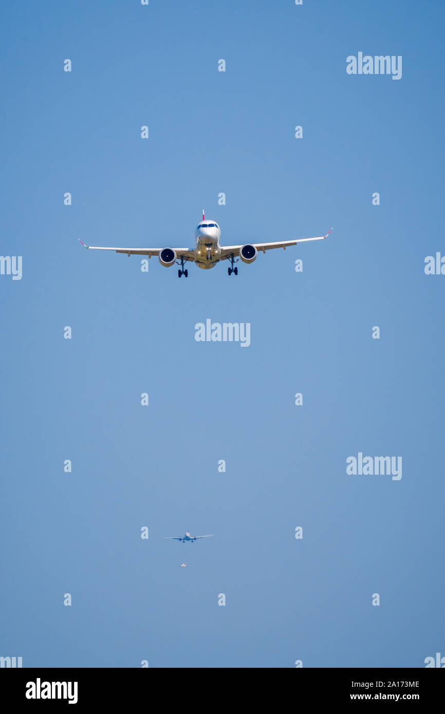 Passenger airplane flying in blue sky, front view Stock Photo - Alamy