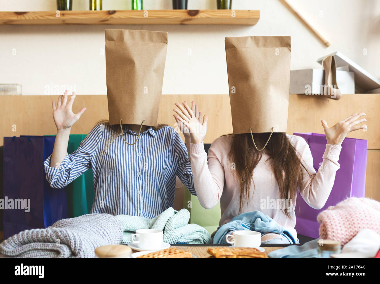 Two friends put on paper bags on their heads in cafe Stock Photo - Alamy