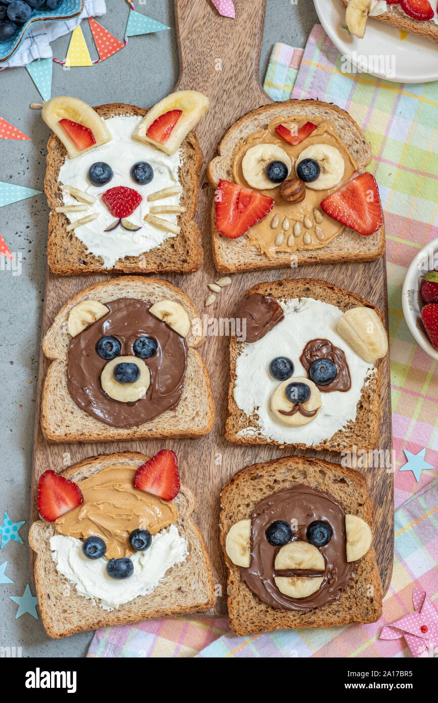 Funny animal faces toasts with spreads, butters, banana, strawberry and ...