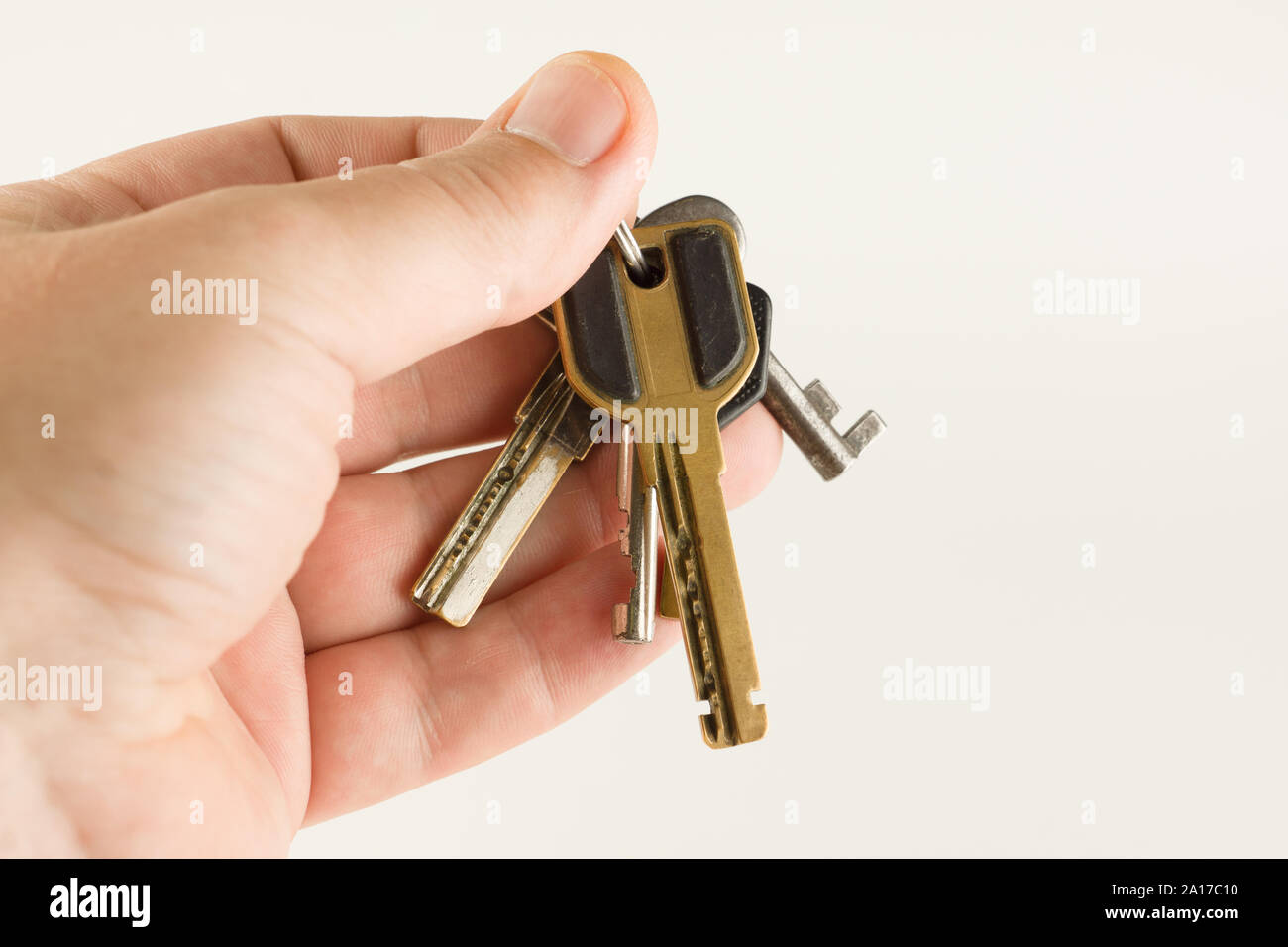 big bunch of different keys in hand isolated on a white background ...