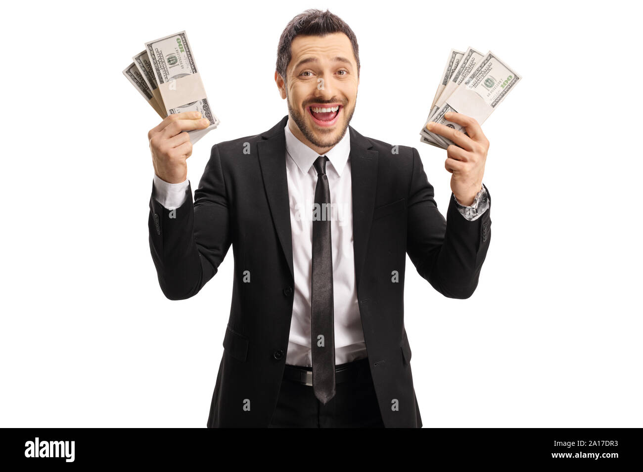 Excited man in a black suit holding stacks of cash in both hands ...