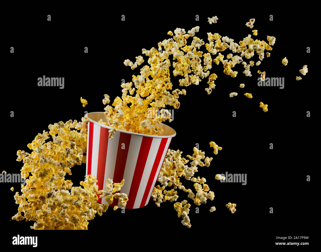 Flying popcorn from striped bucket isolated on black background Stock ...