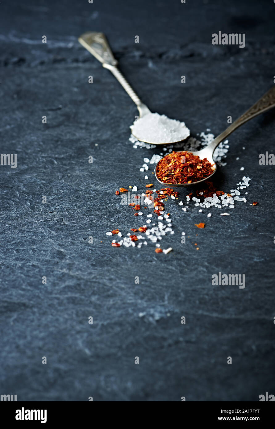 Ground chili pepper and rock salt on spoons Stock Photo - Alamy