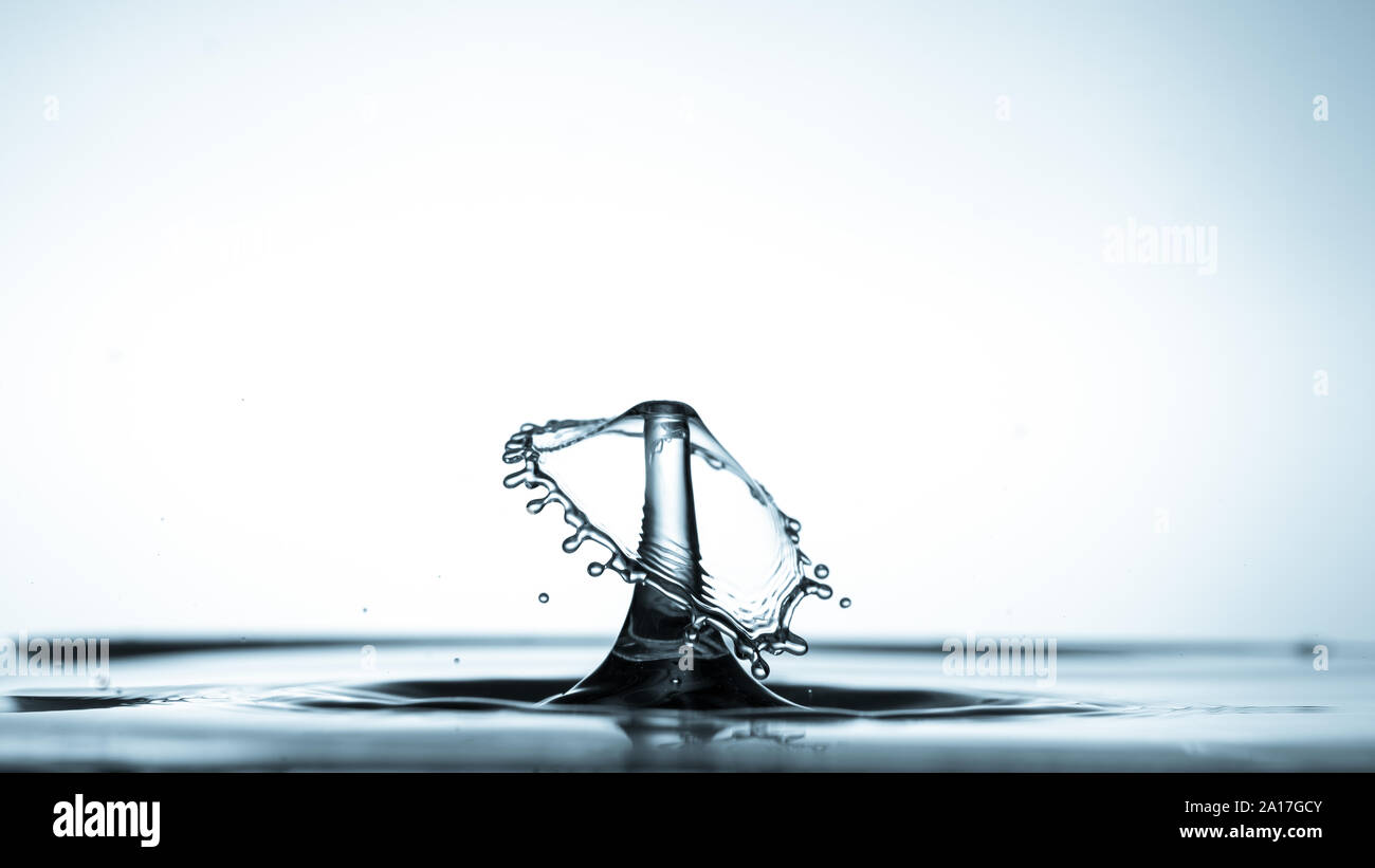 Close-up of a water drop falling on water surface Stock Photo - Alamy
