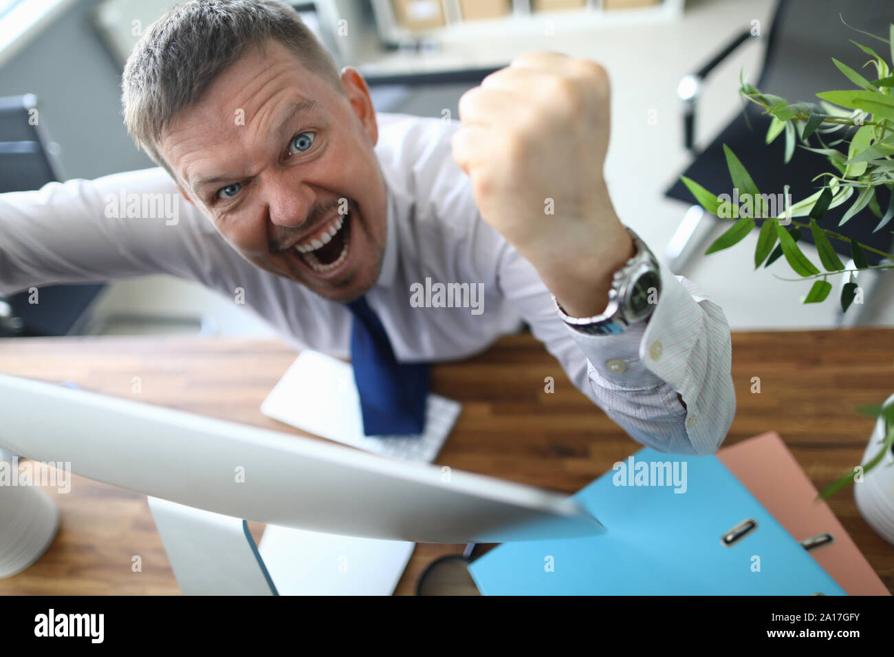 Crazy boss screams threatens with a fist and looks Stock Photo - Alamy