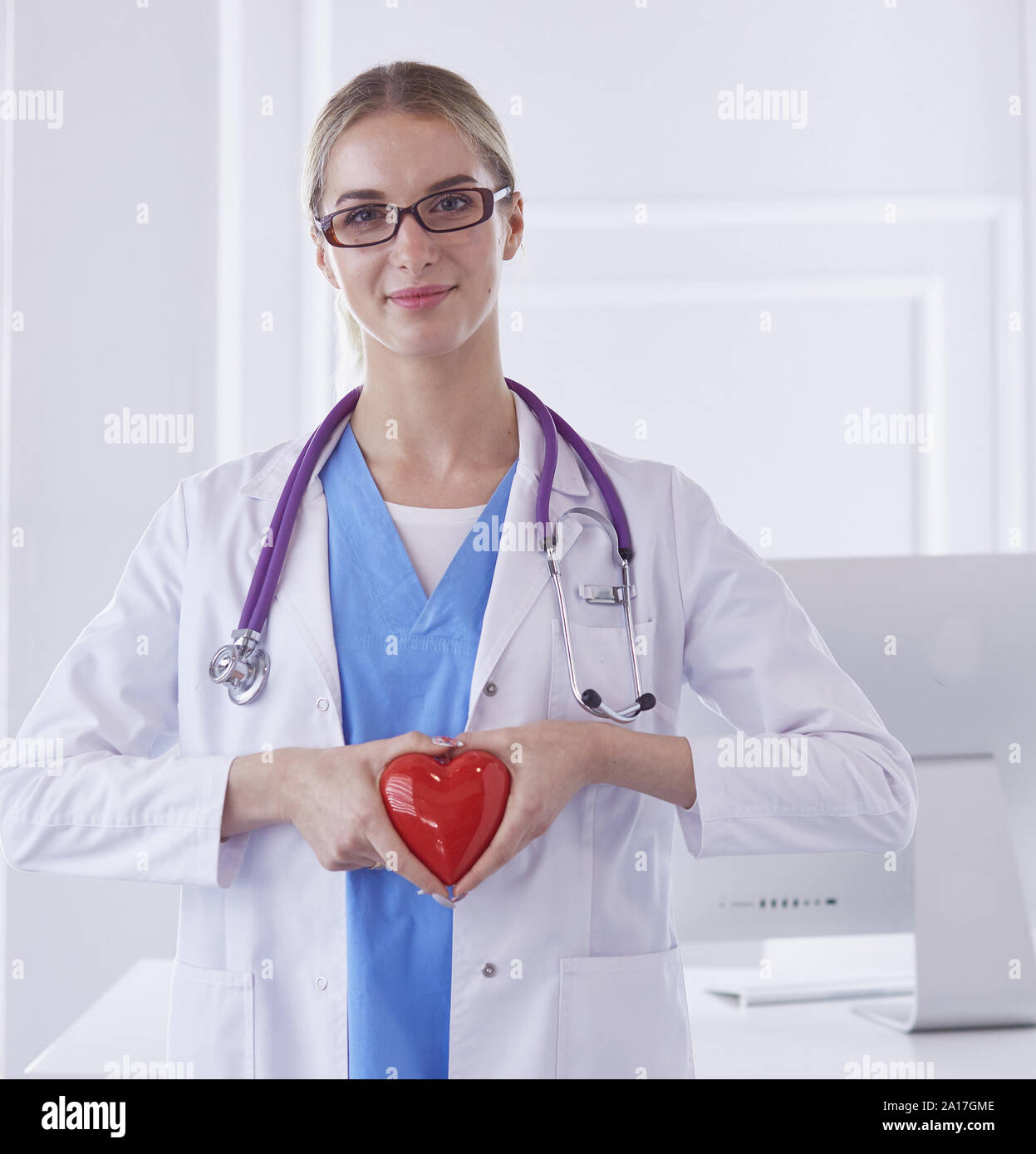 Doctor with stethoscope holding heart, isolated on white background ...