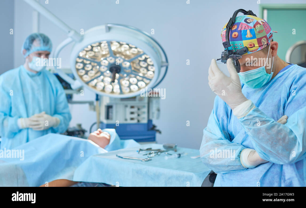 Several doctors surrounding patient on operation table during their ...