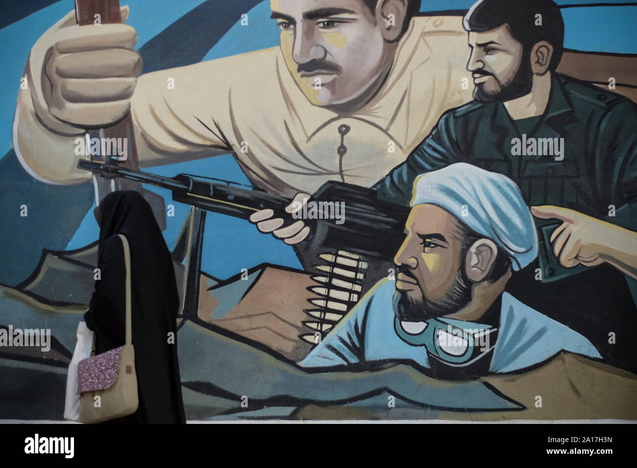 Tehran, Iran. 24th Sep, 2019. Pedestrians walk past political murals at ...