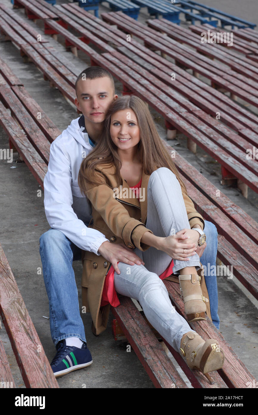 Stylish young couple hugging at a sports stadium outdoor. Smiling ...