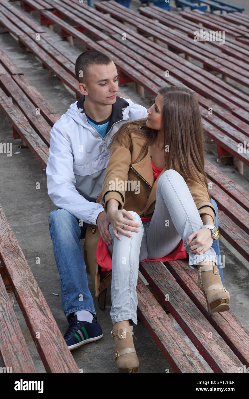 Stylish young couple hugging at a sports stadium outdoor. Smiling ...