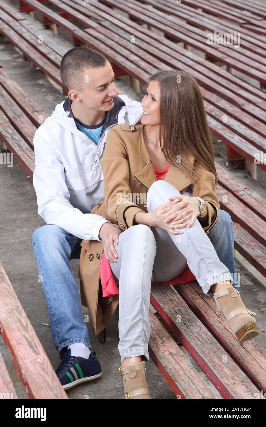 Stylish young couple hugging at a sports stadium outdoor. Smiling ...