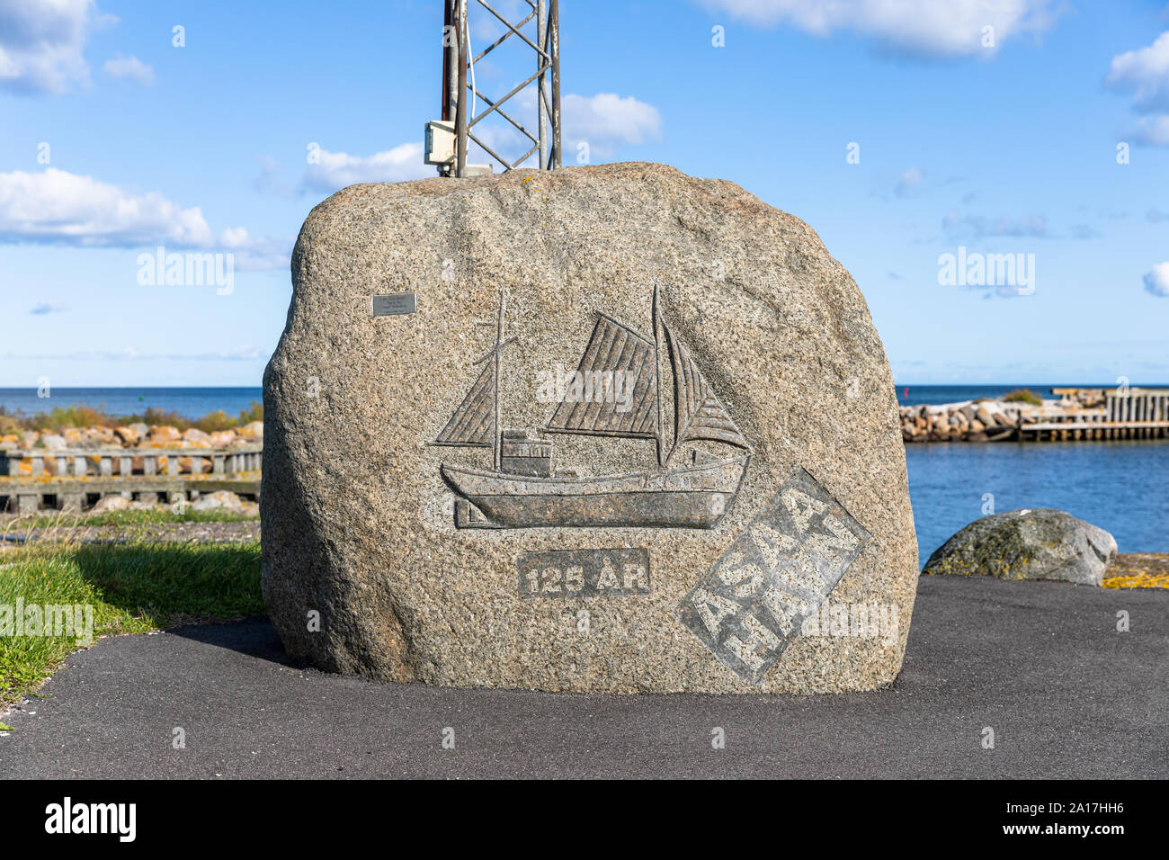 Stone commemorating the 125th jubilee of Asaa Harbour, adorned with a ...