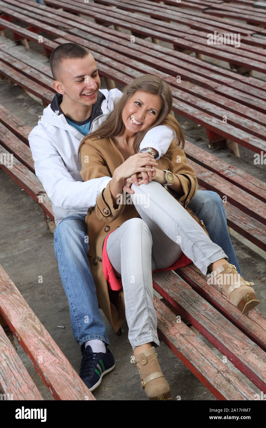 Stylish young couple hugging at a sports stadium outdoor. Smiling ...