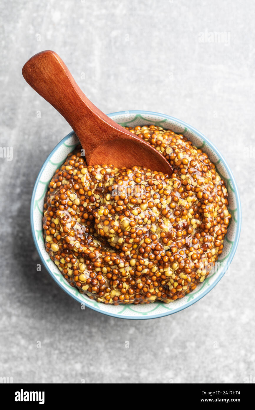 Whole grain mustard in bowl on kitchen table. Top view Stock Photo - Alamy