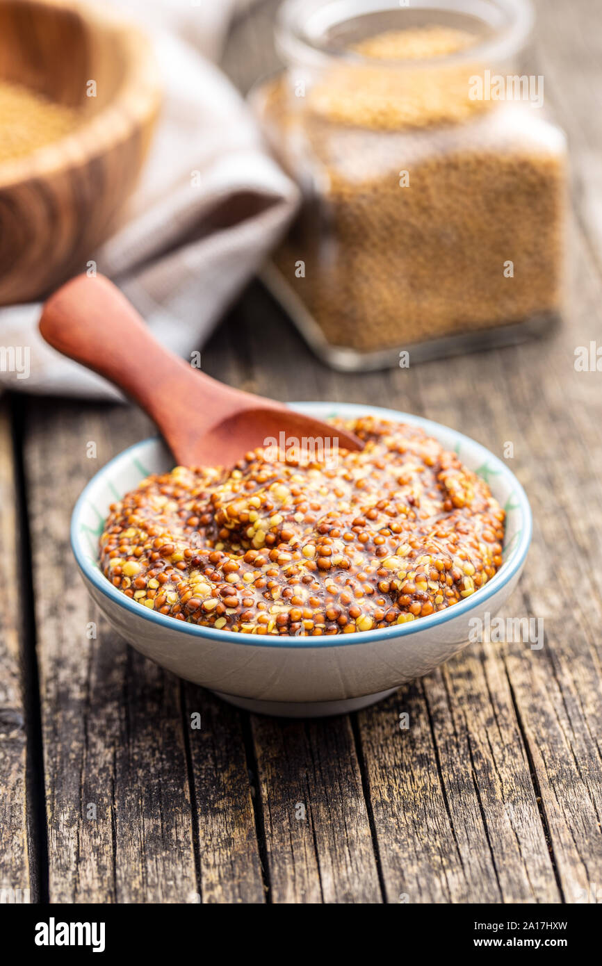 Whole grain mustard in bowl on old wooden table Stock Photo - Alamy