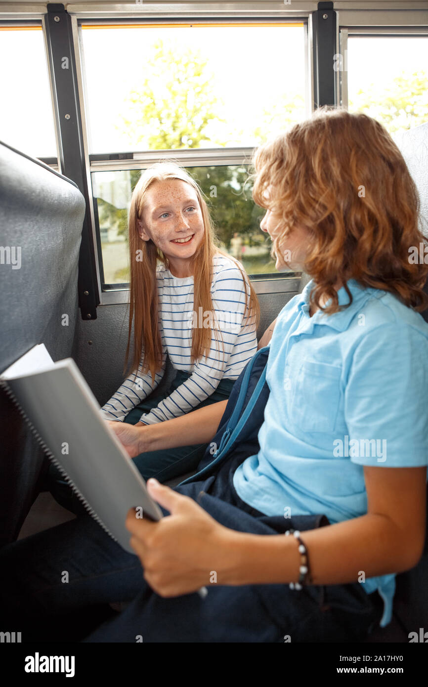 Classmates going to school by bus sitting boy reading book and girl ...