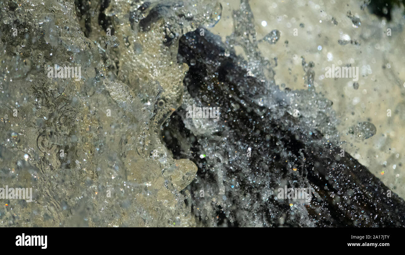 Water backgrounds with foam spray fast flow.The log is stuck in ...